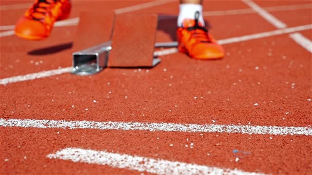 Single track and field sprinter in a stadium starting out of the block ...