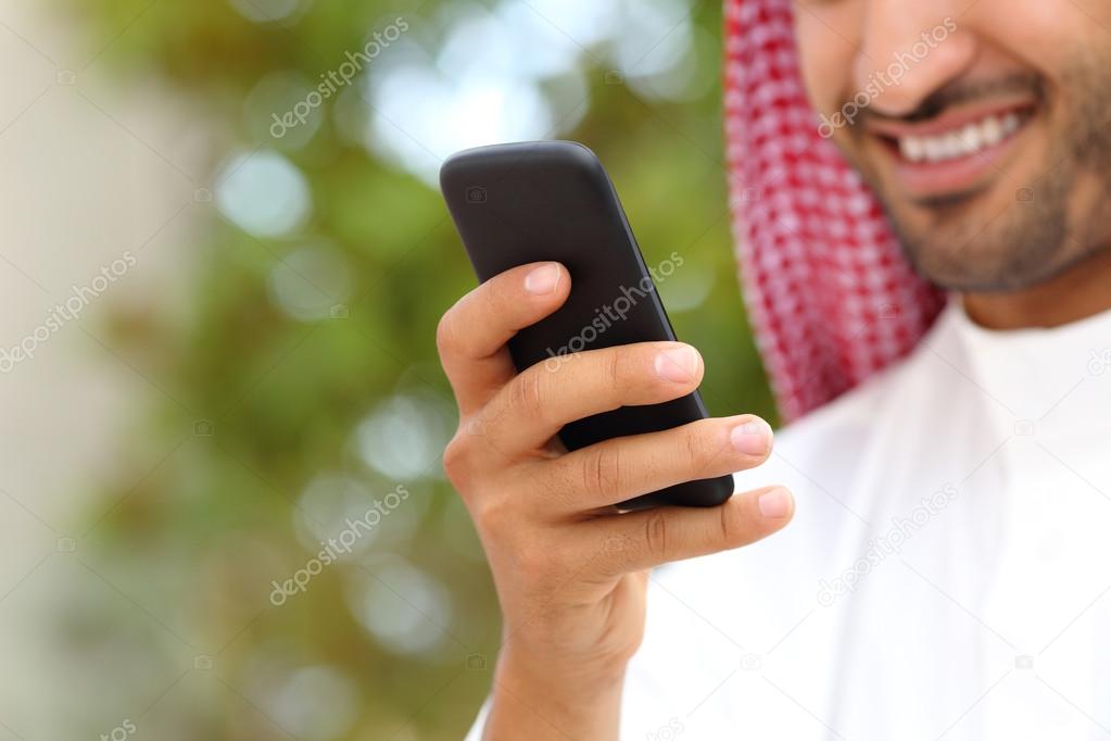 Smiling arab saudi man hand using a smart phone outdoor — Stock Photo ...