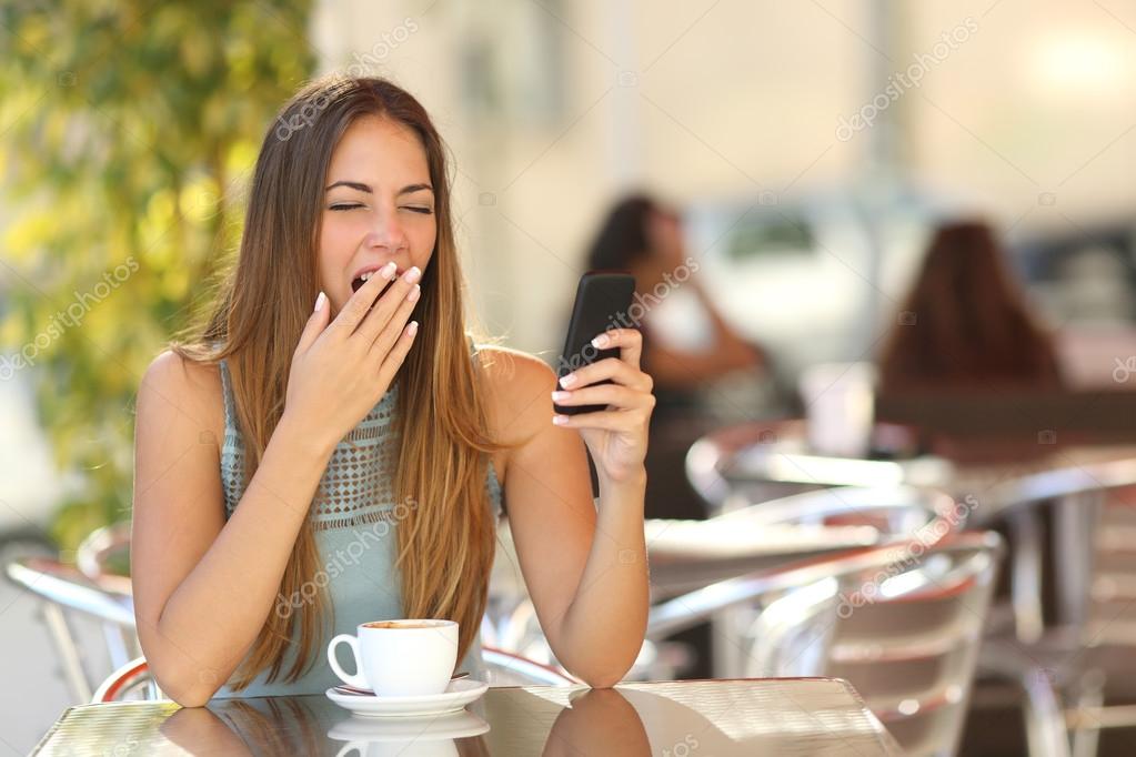 Mujer bostezando mientras está trabajando en el desayuno en un ...