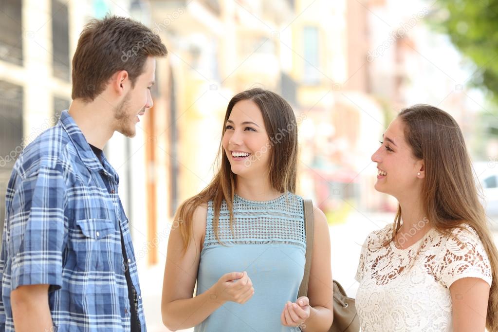 Tres amigos hablando teniendo una conversación en la calle: fotografía ...