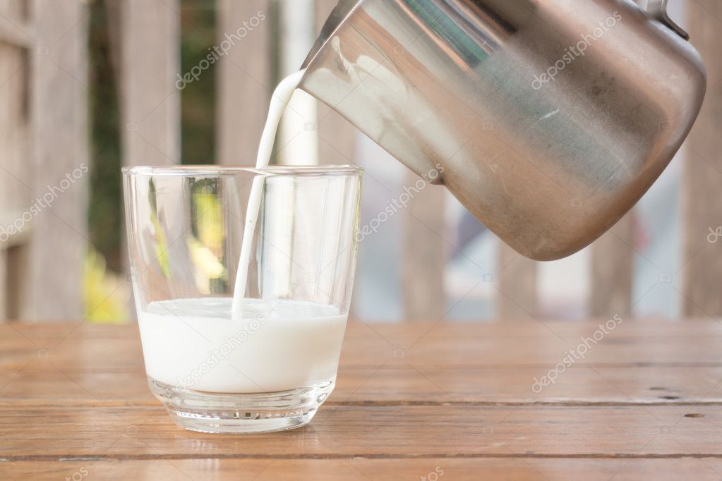 Pour milk from a pitcher into a glass Stock Photo by ©nalinrat 101334752