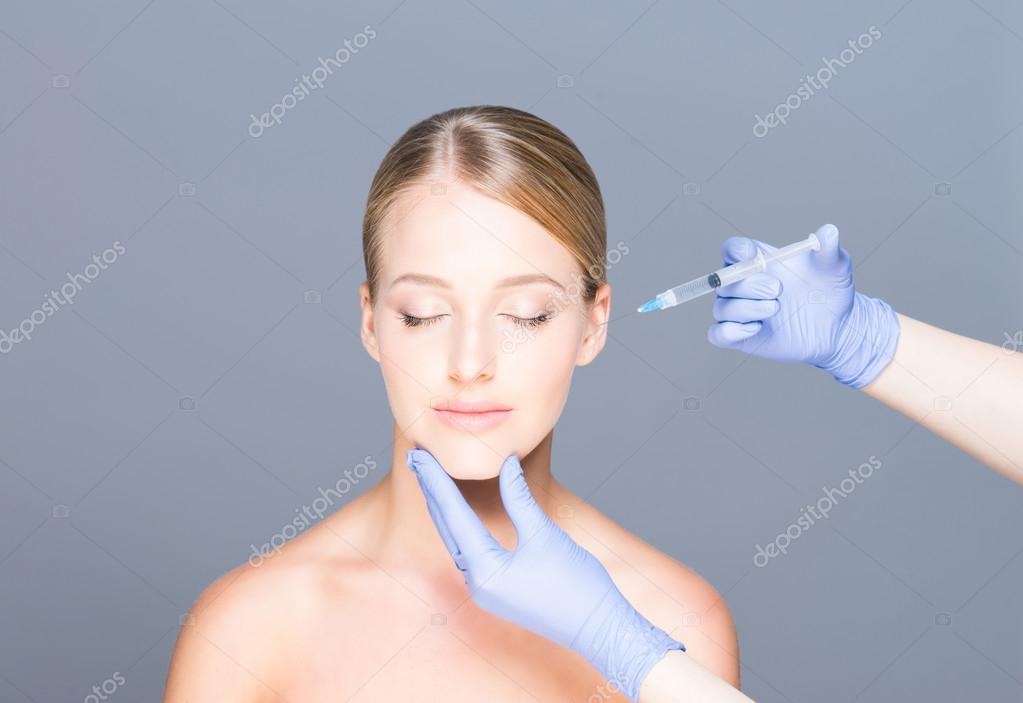 Doctor injecting botox in a beautiful face of a young woman Stock Photo ...