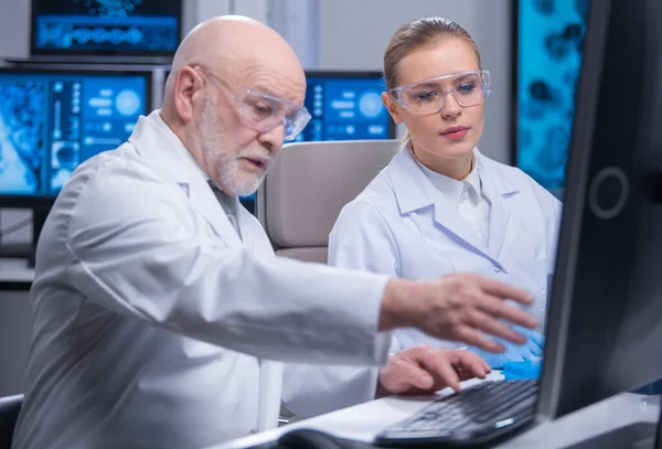 Professor and his young and professional laboratory assistant are doing ...