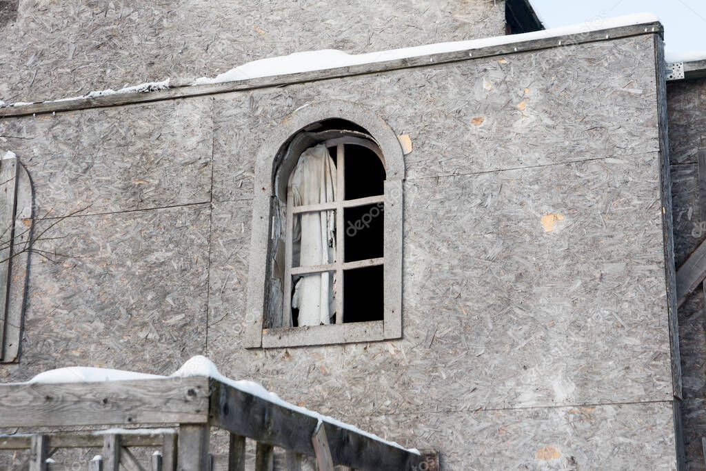 Ventanas tapiadas de una casa vieja. Detalles del edificio abandonado de la ciudad 2023