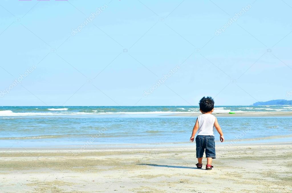 Kid walking alone at the beach Stock Photo by ©shahril 56124281