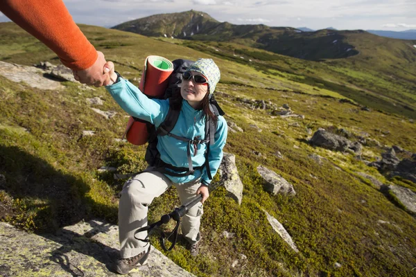 Helping hand - hiker woman getting help on hike smiling happy ...