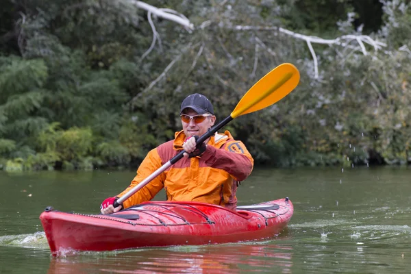 Kayaking on the river.Young man paddling hard the kayak with lots of ...