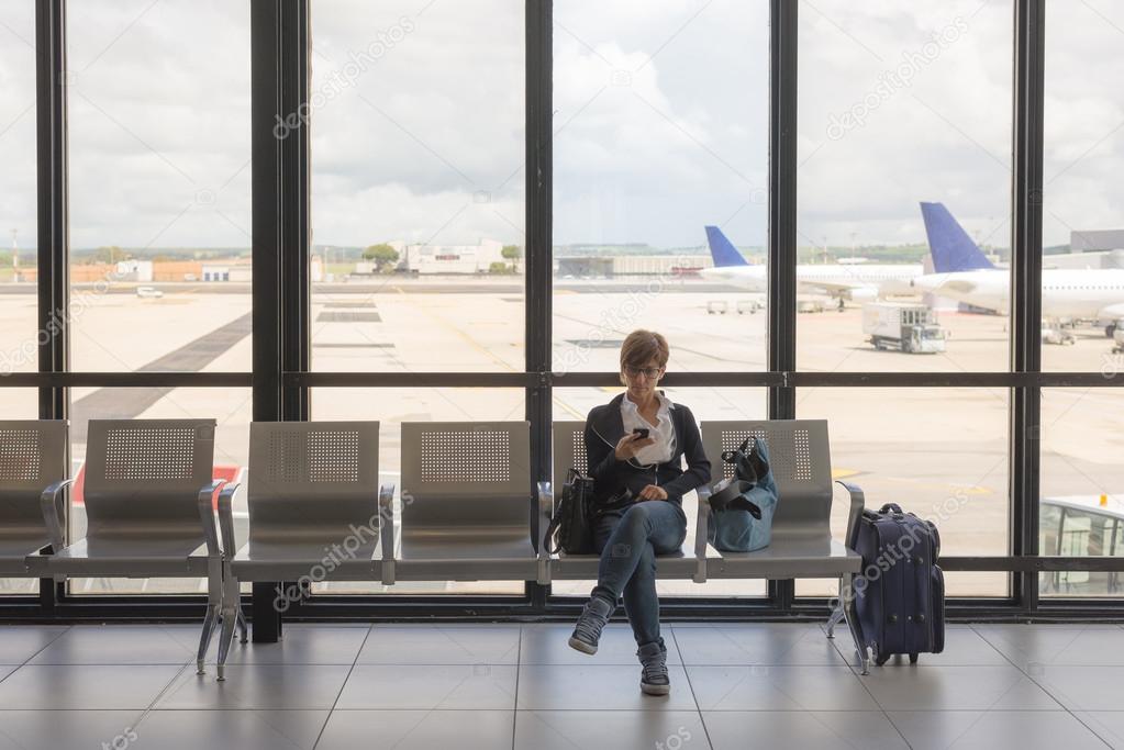 Waiting in airport terminal using phone — Stock Photo © fbxx #74670981