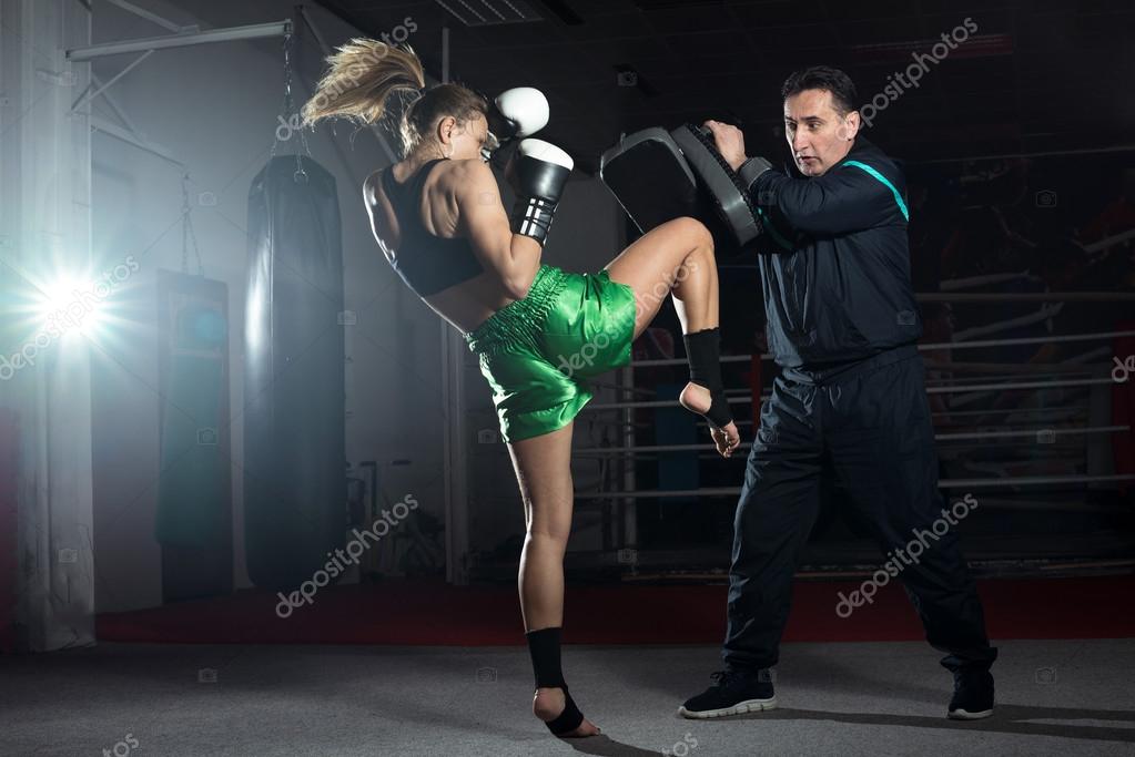 Boxing girl doing knee kick — Stock Photo © ozimicians #101284604