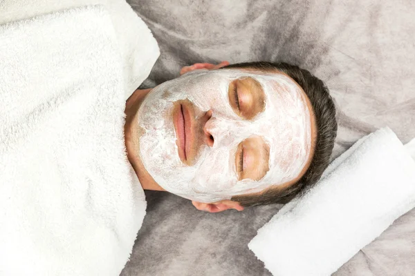 Man laying with cream mask - Stock Image - Everypixel