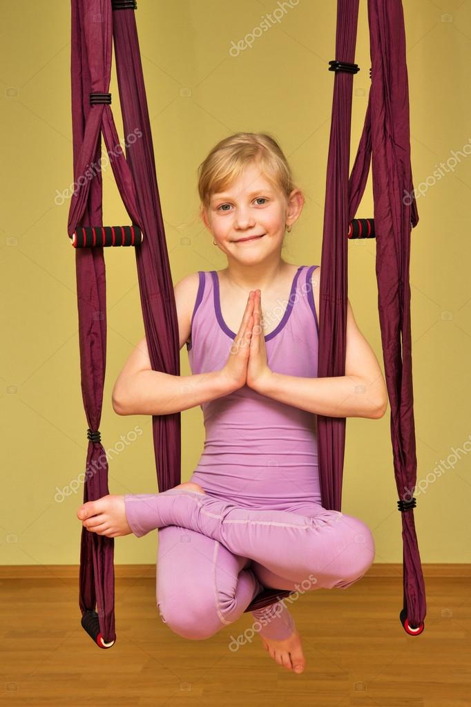 Little girl making aerial yoga exercises, indoor — Stock Photo ... Little girl making aerial yoga exercises, indoor — Stock Photo ...