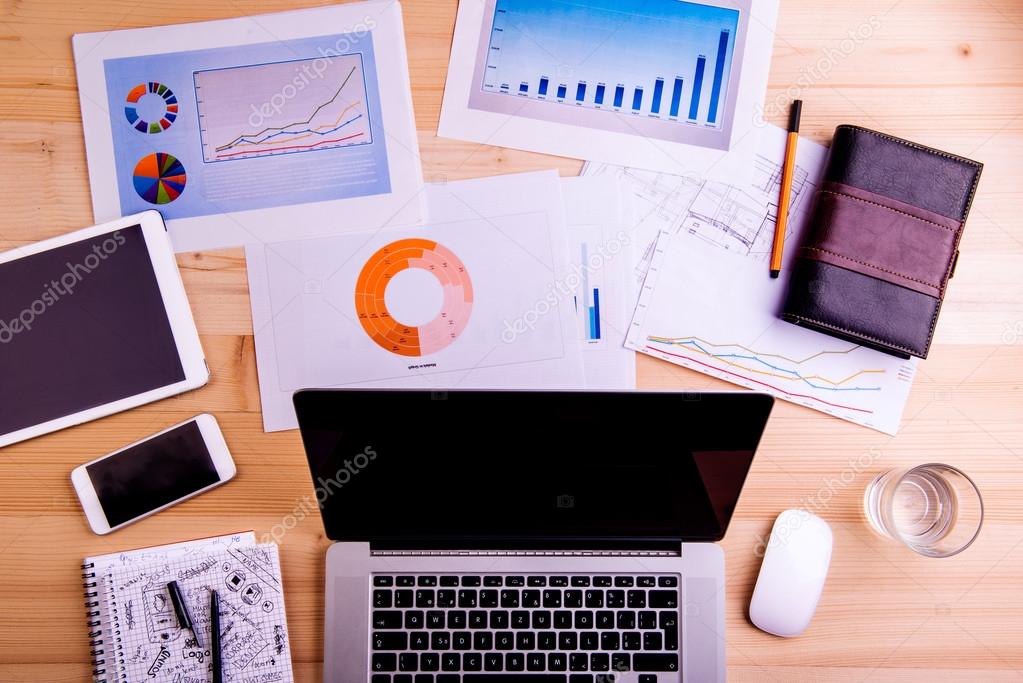 Gadgets and office supplies, chart graph. Wooden background. Stock ...