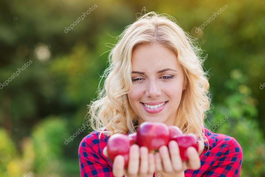 Beautiful woman harvesting apples, eating them — Stock Photo ...