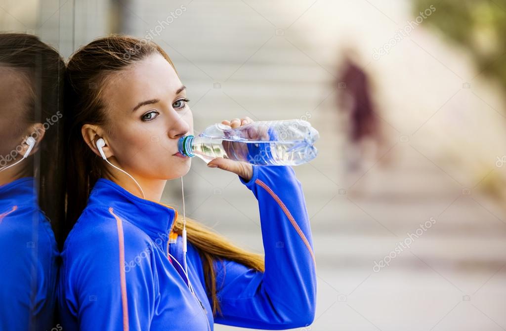 Female runner drinking water during the run — Stock Photo © halfpoint ...