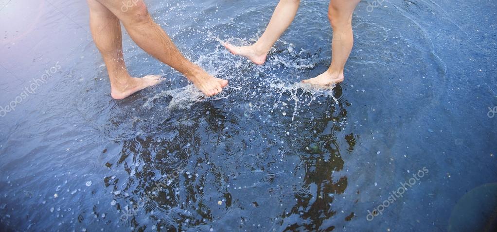 Feet walking in puddle Stock Photo by ©halfpoint 70886495