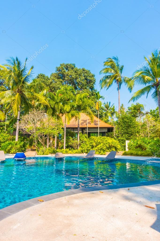 Swimming pool with palm trees and sea — Stock Photo © mrsiraphol #104998508