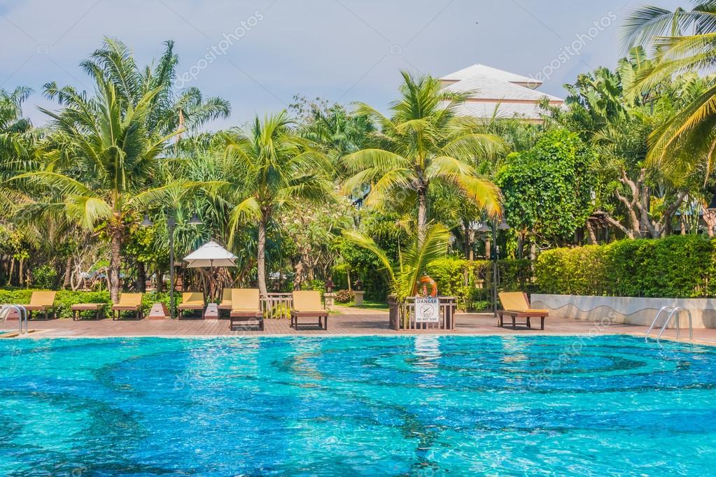 Swimming pool with palm trees and sea — Stock Photo © mrsiraphol #105903136