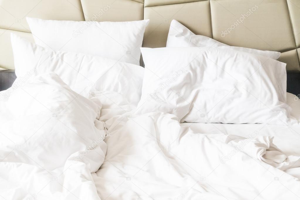 Rumpled bed with white messy pillow Stock Photo by ©mrsiraphol 117532984