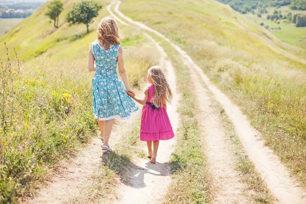 Mother and daughter walking in the field Stock Photo by ©apid 66594269