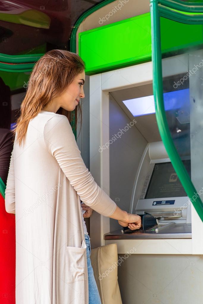 Woman standing near ATM machine Stock Photo by ©Geribody 85771832