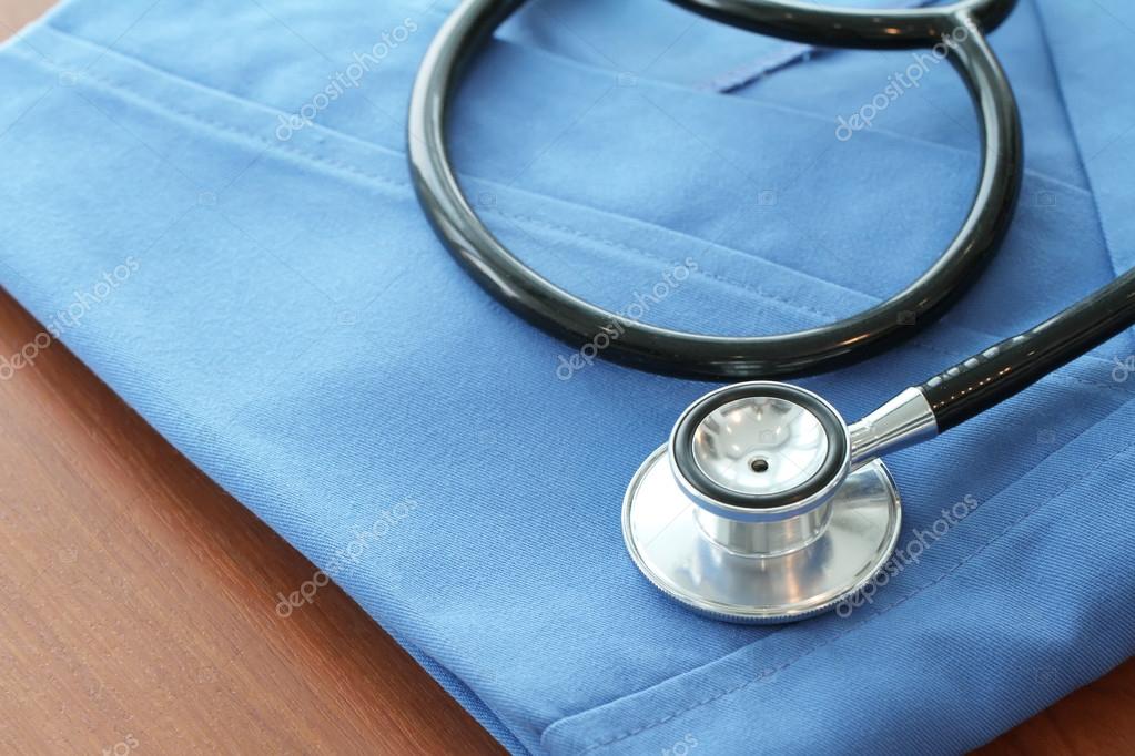 Stethoscope with blue doctor coat on wooden table and backgroun Stock ...