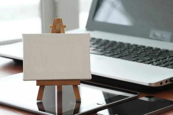 Blank canvas and wooden easel on laptop computer as concept Stock Photo ...