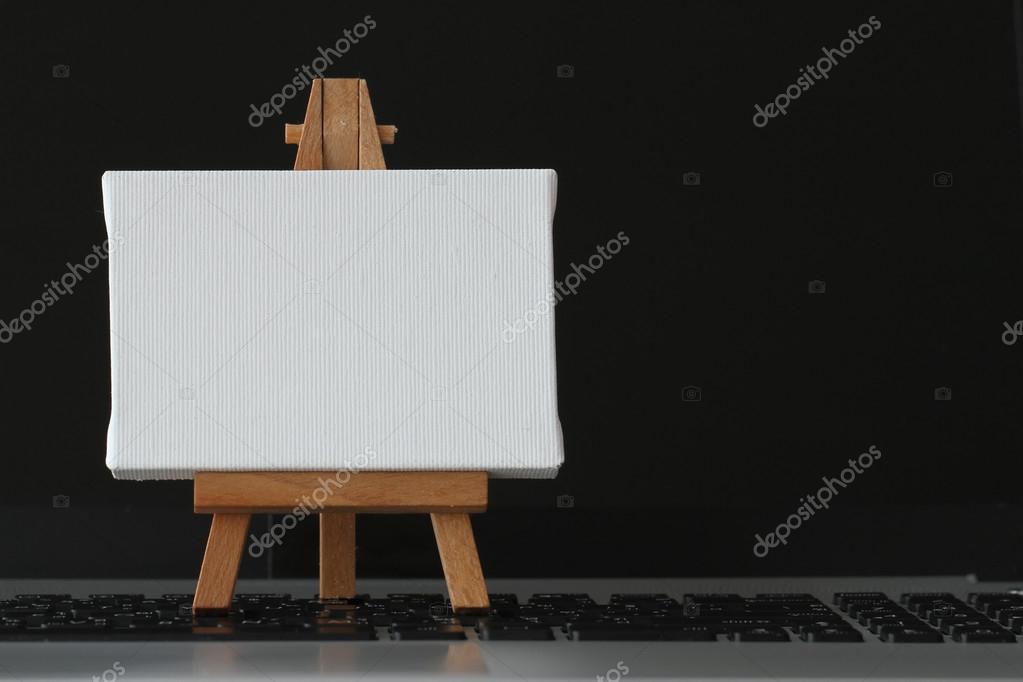 Blank canvas and wooden easel on laptop computer as concept — Stock ...