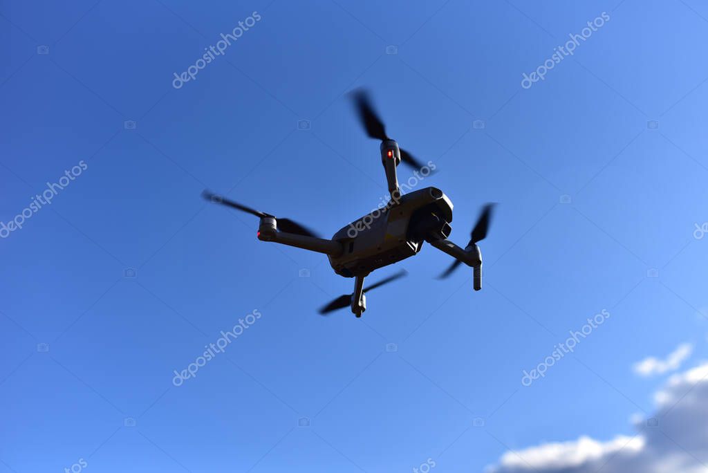 Drone volando en el aire sobre fondo azul del cielo. Quadcopter con ...