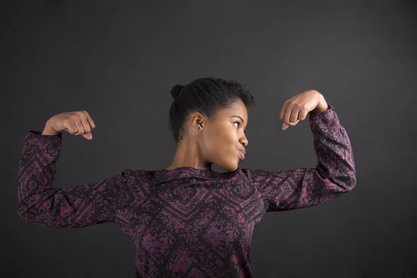 African American woman with strong arms and strength on blackboard ...