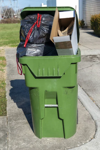 Vertical shot of a very full plastic trash can. - Stock Image - Everypixel