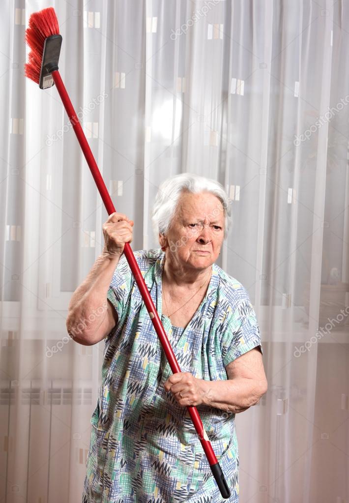 Old angry woman threatening with a broom — Stock Photo © VBaleha #75608843 Old angry woman threatening with a broom — Stock Photo © VBaleha #75608843