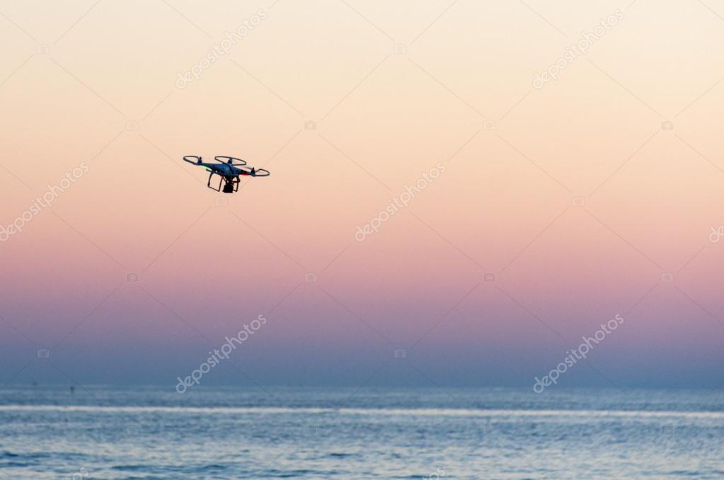 Drone volador con cámara en el cielo al atardecer 2024