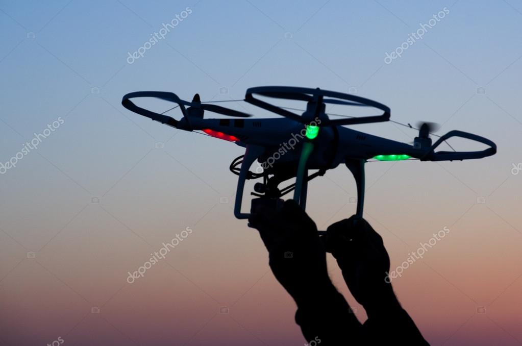 Drone volador con cámara en el cielo al atardecer 2024