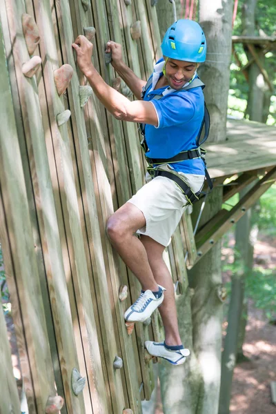 Climber in climbing wall at high rope course - Stock Image - Everypixel