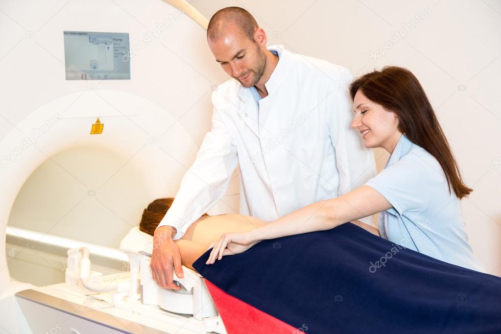 Assistante technique médicale préparant le scan de la colonne ...