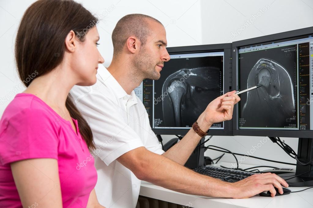 Radiologist councelling a patient using images from tomograpy or MRI ...