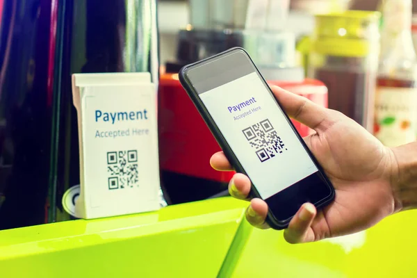 Customer hand using smart phone to scan Qr code payment tag with blurry ...