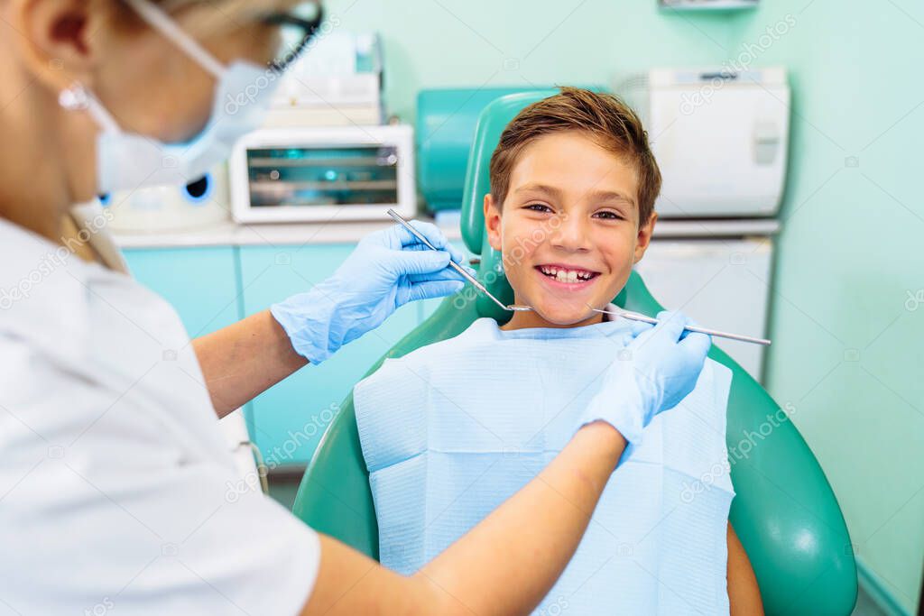 Niño pequeño y joven paciente está feliz con una visita al dentista. Concepto de tratamiento ...