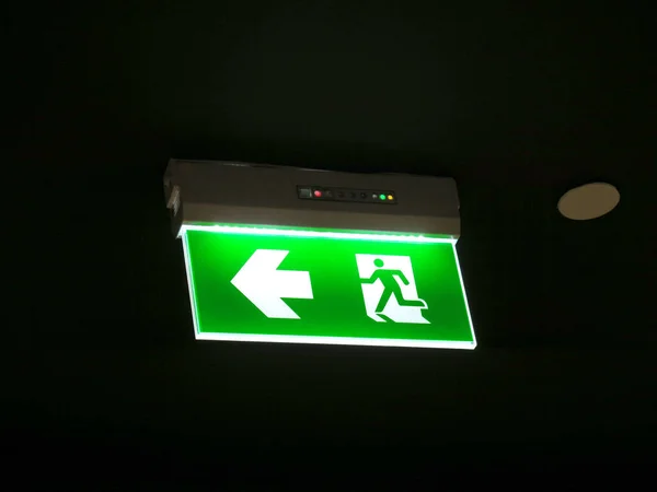 emergency exit sign on a black background - Stock Image - Everypixel
