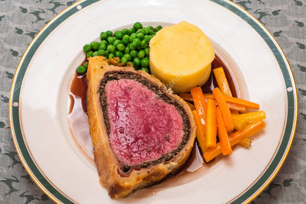 Rebanada de filete de carne Wellington con salsa de vino tinto y puré ...