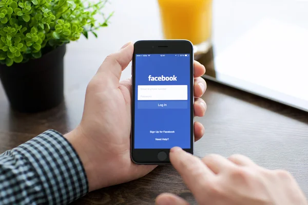 Man holding iPhone 6 with Facebook on the screen - Stock Image - Everypixel