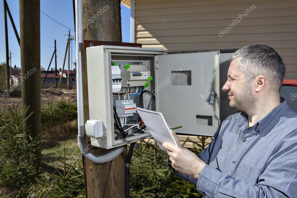Rural Technician Taking Reading Of Electric Meter in the countryside ...