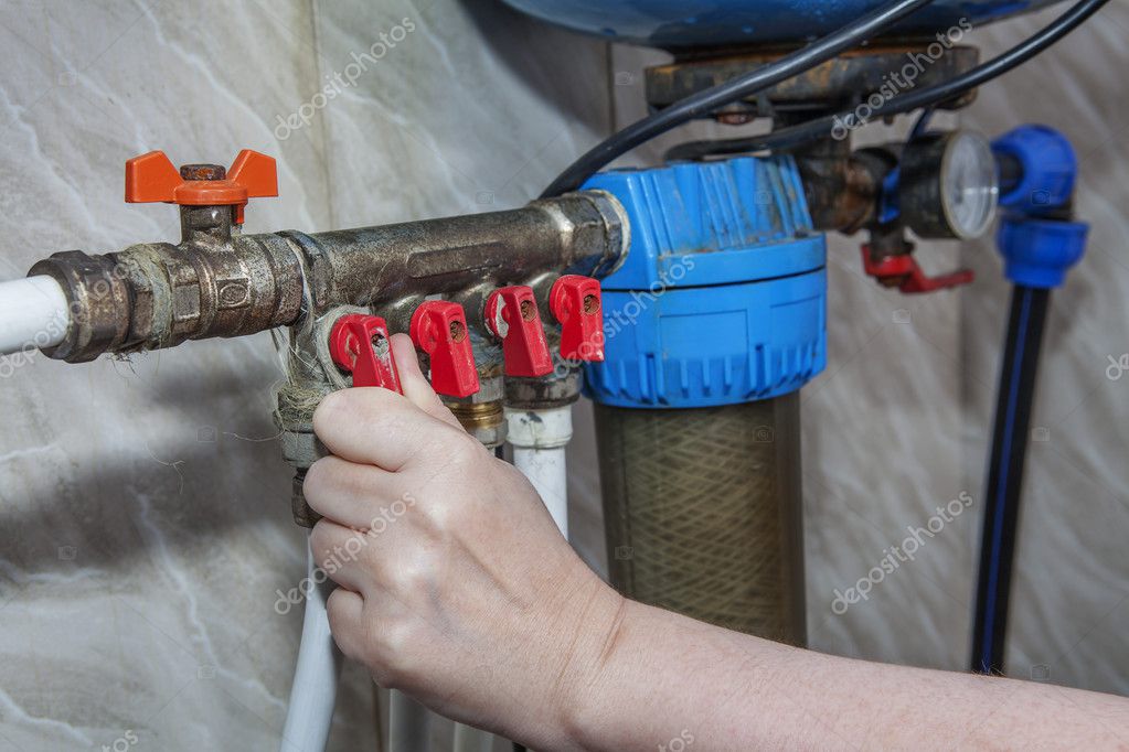 Valves blocking access to water pipes, hand closed faucet, close-up ...