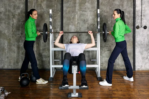 Bench press on training women in gym, young woman doing barbell ...