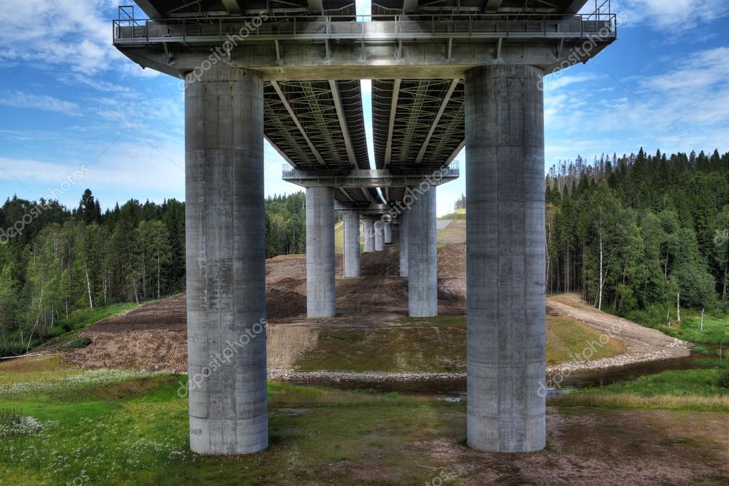 Unfinished steel road bridge on concrete pillars, crosses bed stream ...