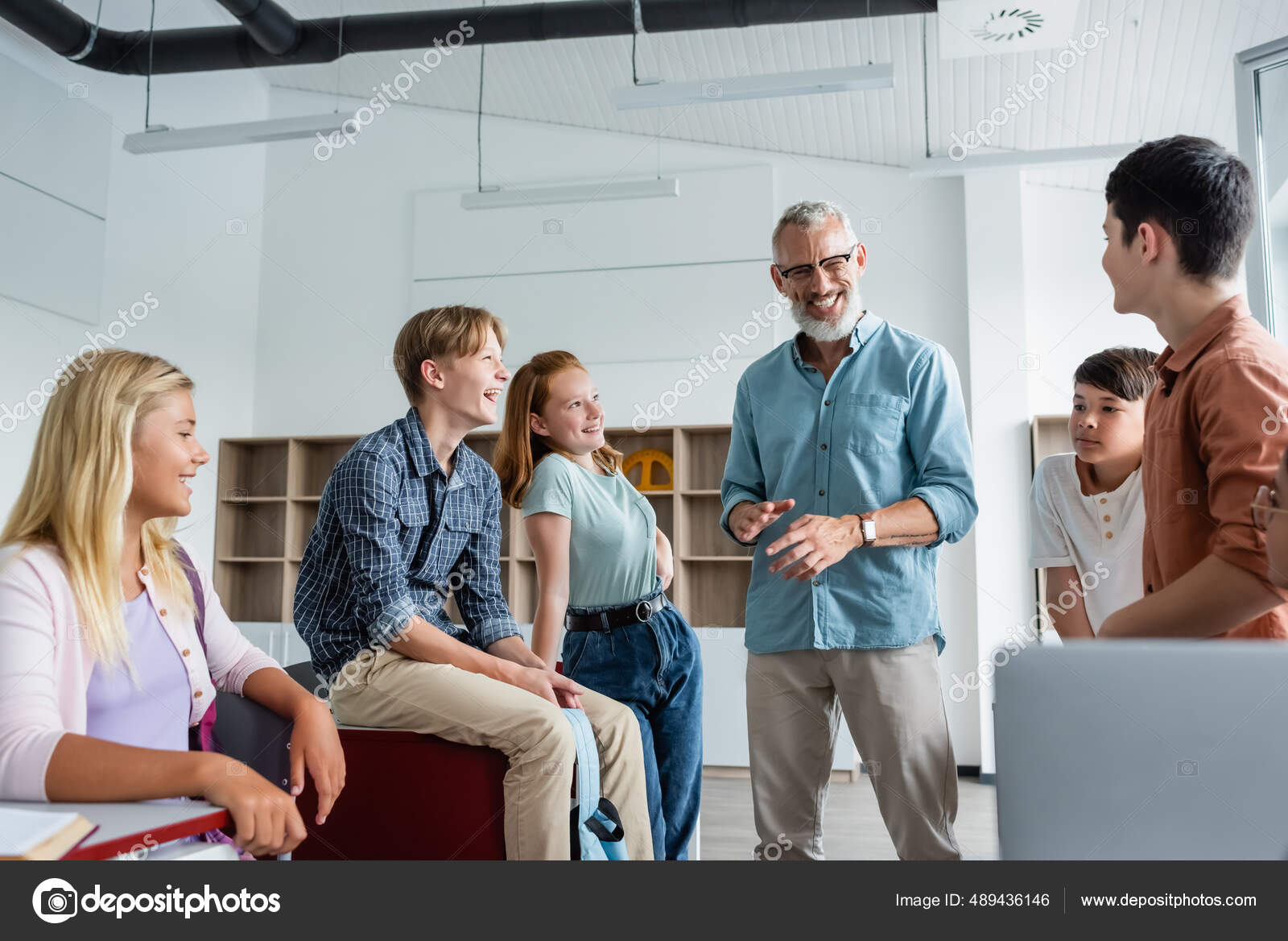 Smiling Teacher Gesturing While Talking Multiethnic Pupils Classroom ...