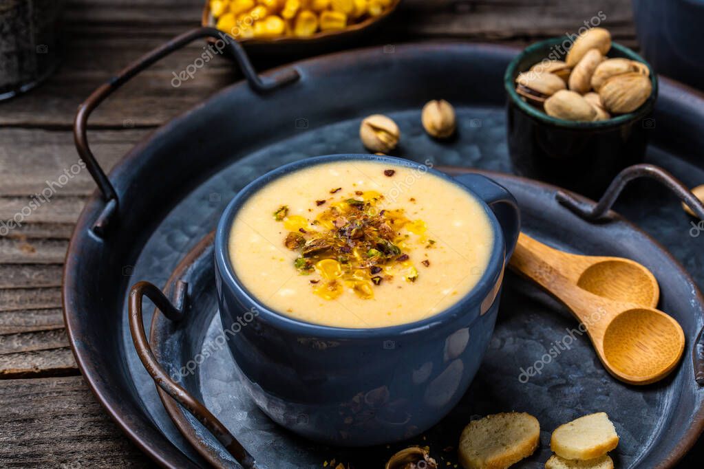sopa de crema de queso con maíz, pistachos y croutons sobre un fondo ...