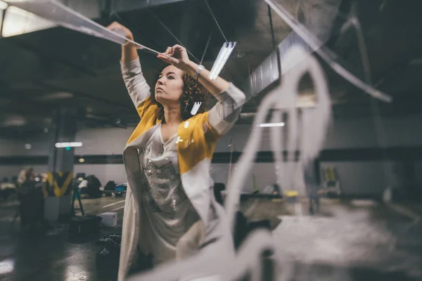 The production designer prepares the scenery on the set. The artist's ...