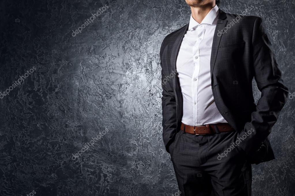 Man in suit against concrete wall Stock Photo by ©AY_PHOTO 119967576