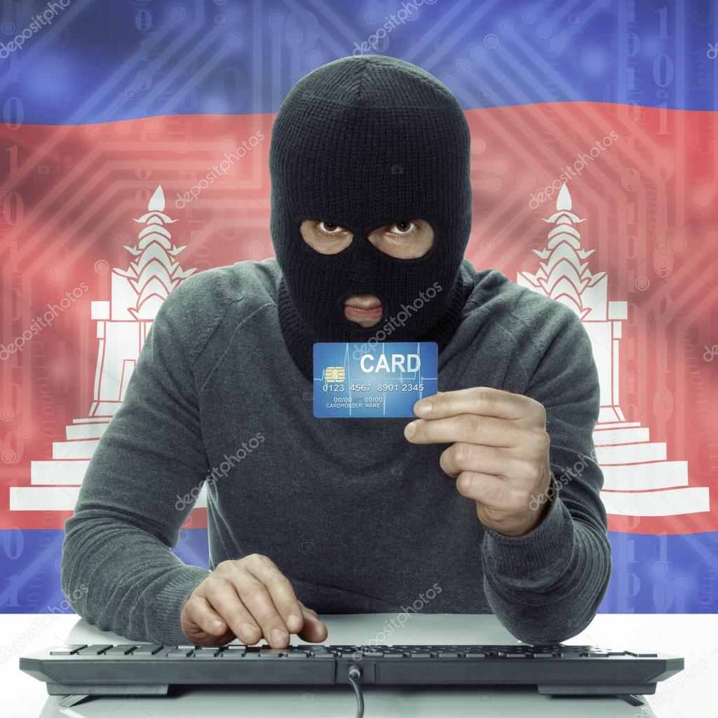 Dark-skinned hacker with flag on background holding credit card in hand ...